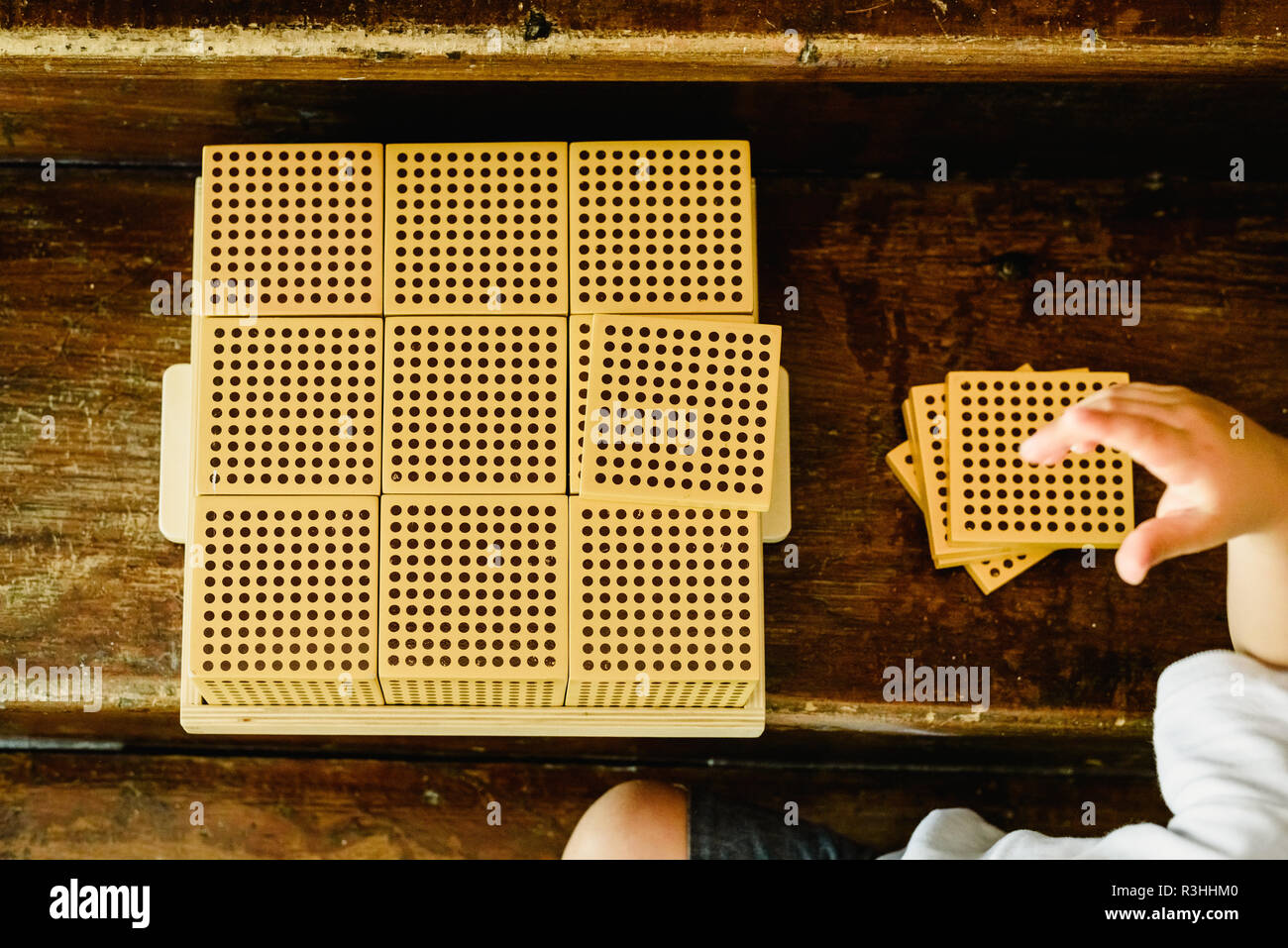 Hands of boy manipulating counting cubes on wooden background in ...