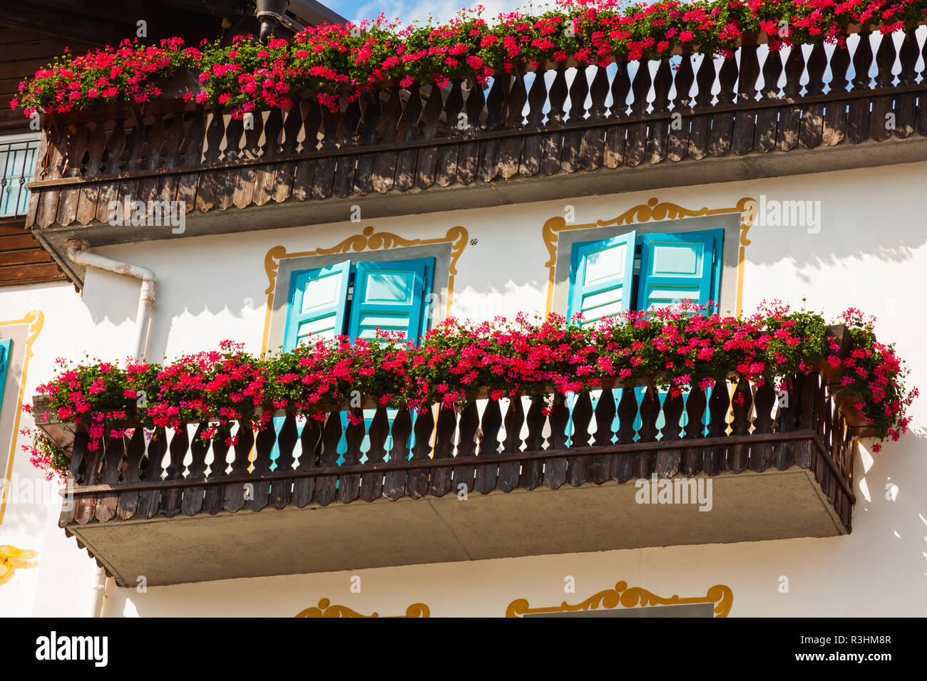 traditional alpine houses with flowers on balcony,cortina d'ampezzo ...