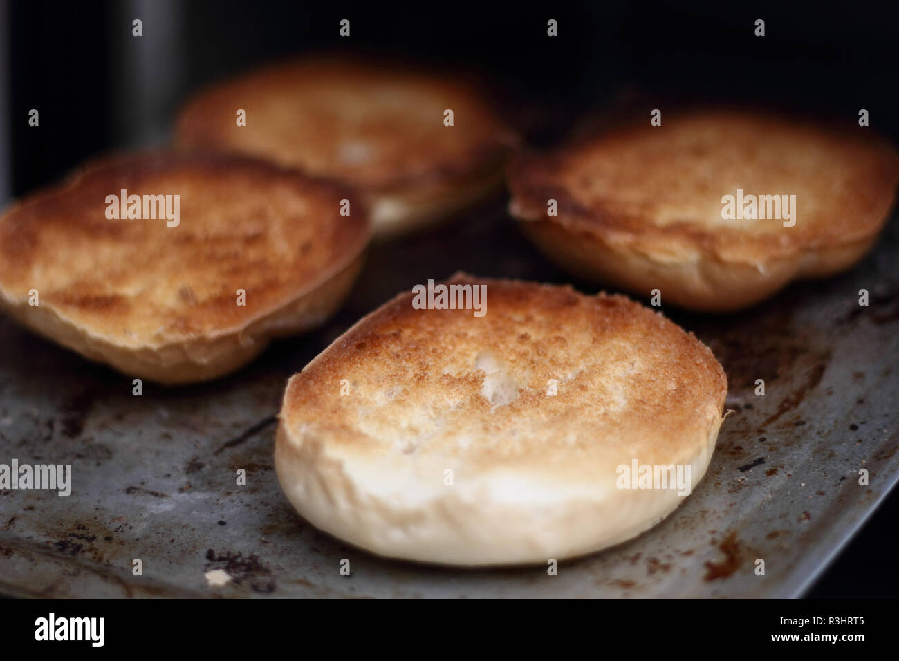 Toasting bread rolls in electric oven Stock Photo - Alamy