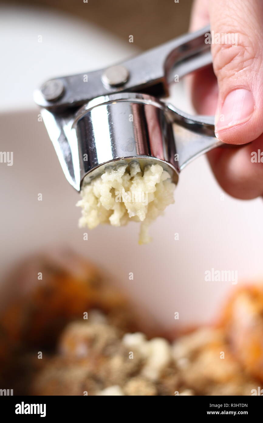Garlic crushed using a garlic press Stock Photo - Alamy
