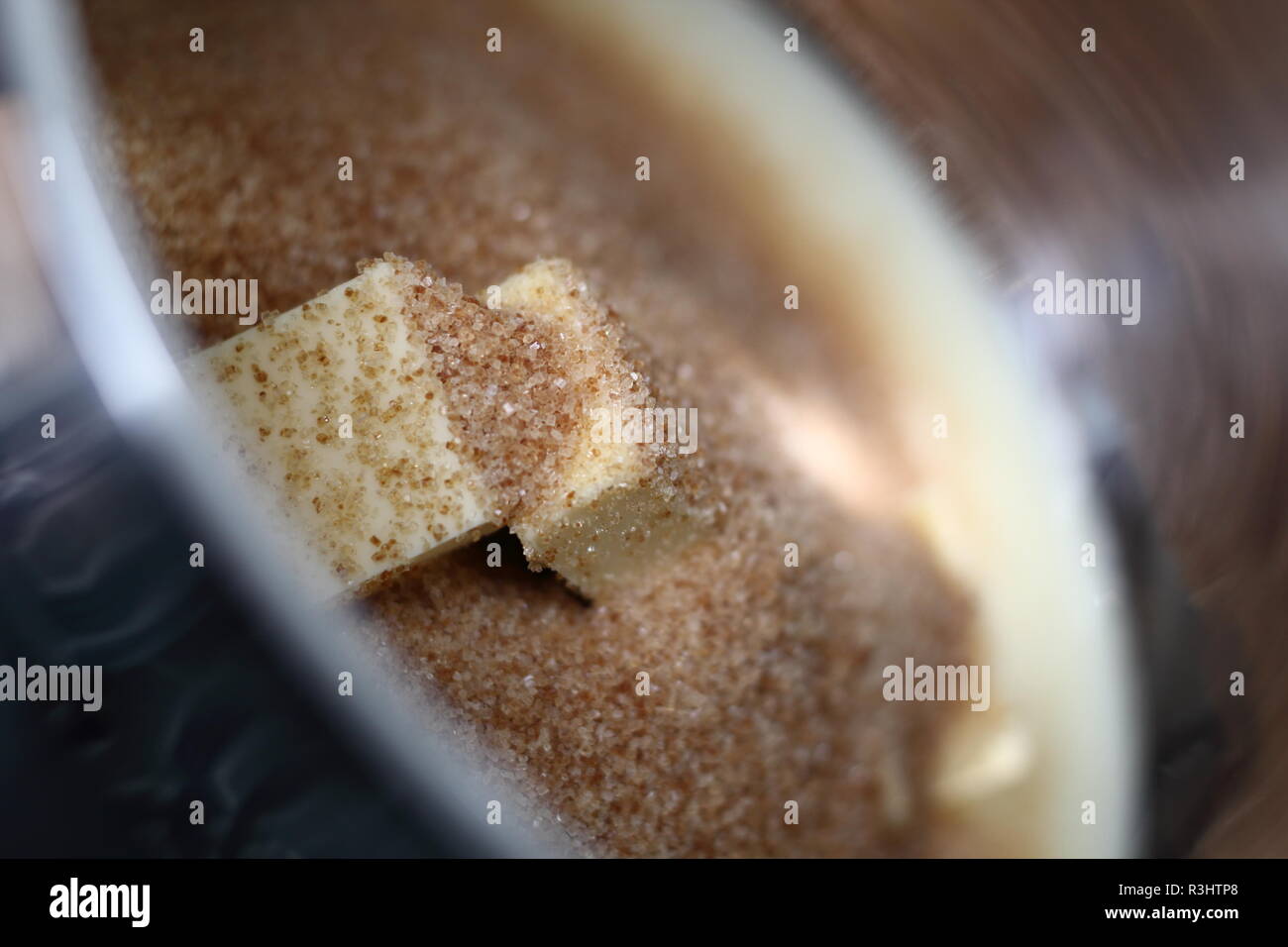 Pouring brown sugar into condensed milk with diced butter. Making ...