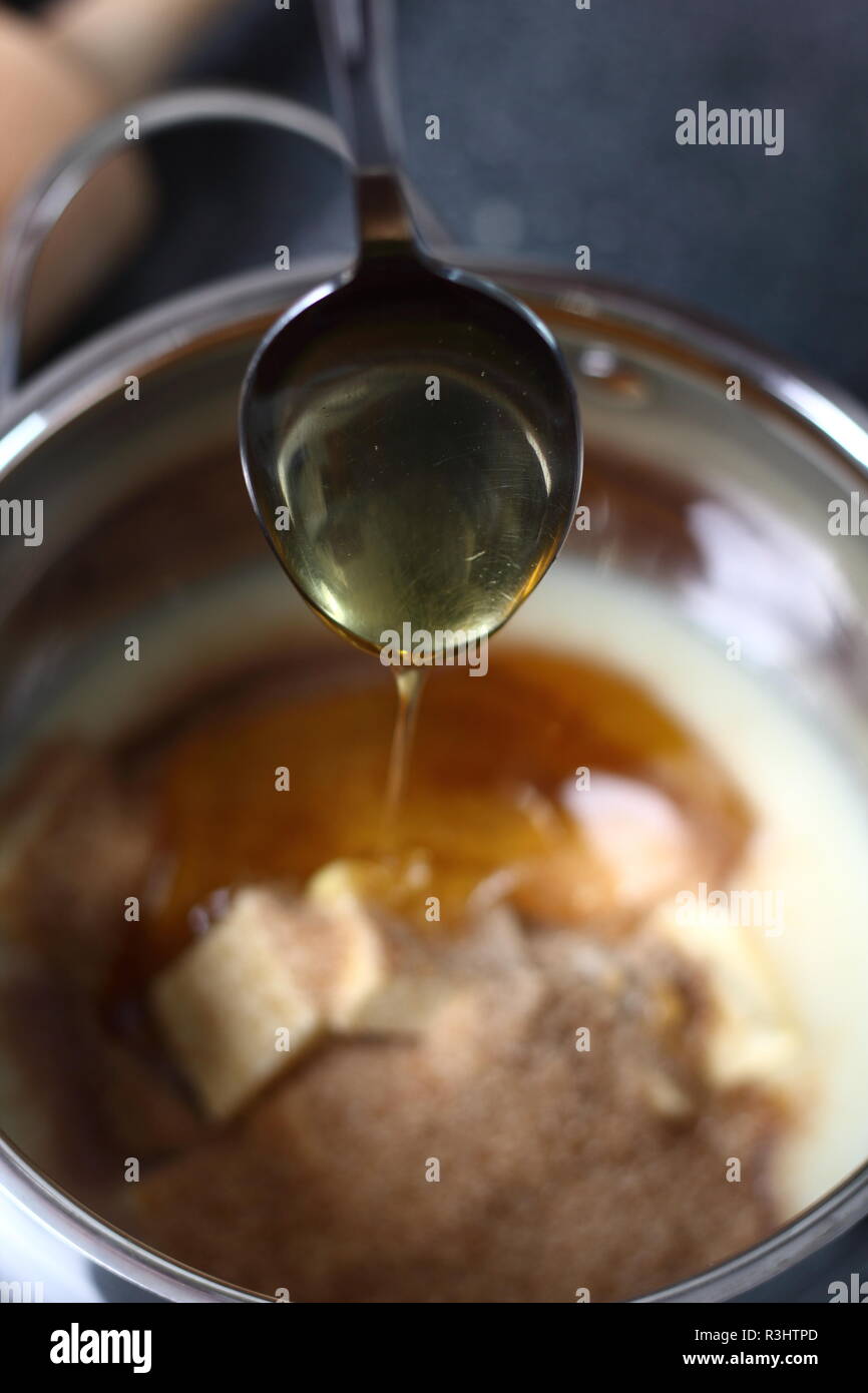 Adding golden syrup into pan with filling ingredients. Making Boston ...