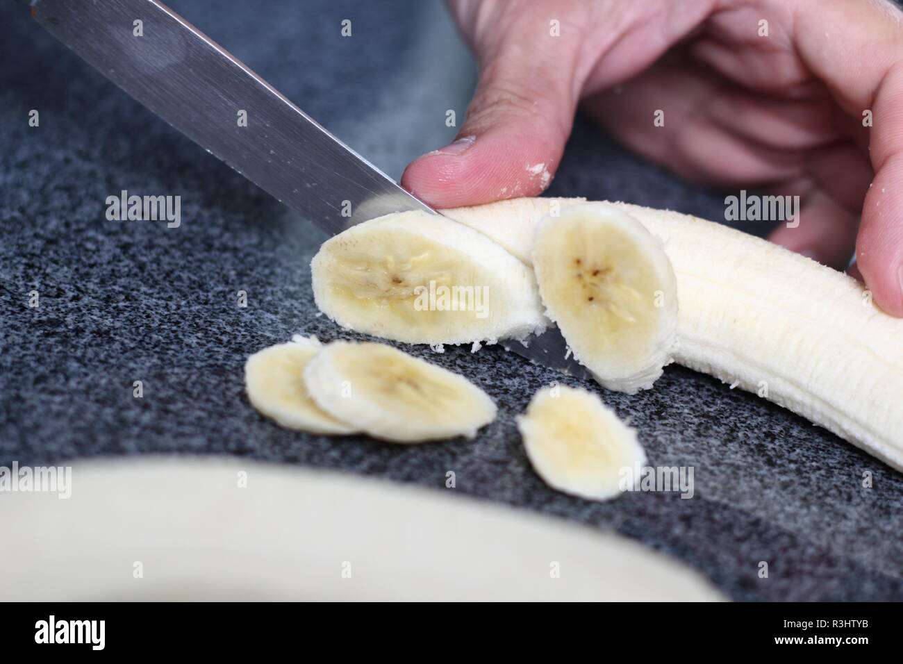 Slicing bananas. Making Boston Banoffee Pie Stock Photo - Alamy