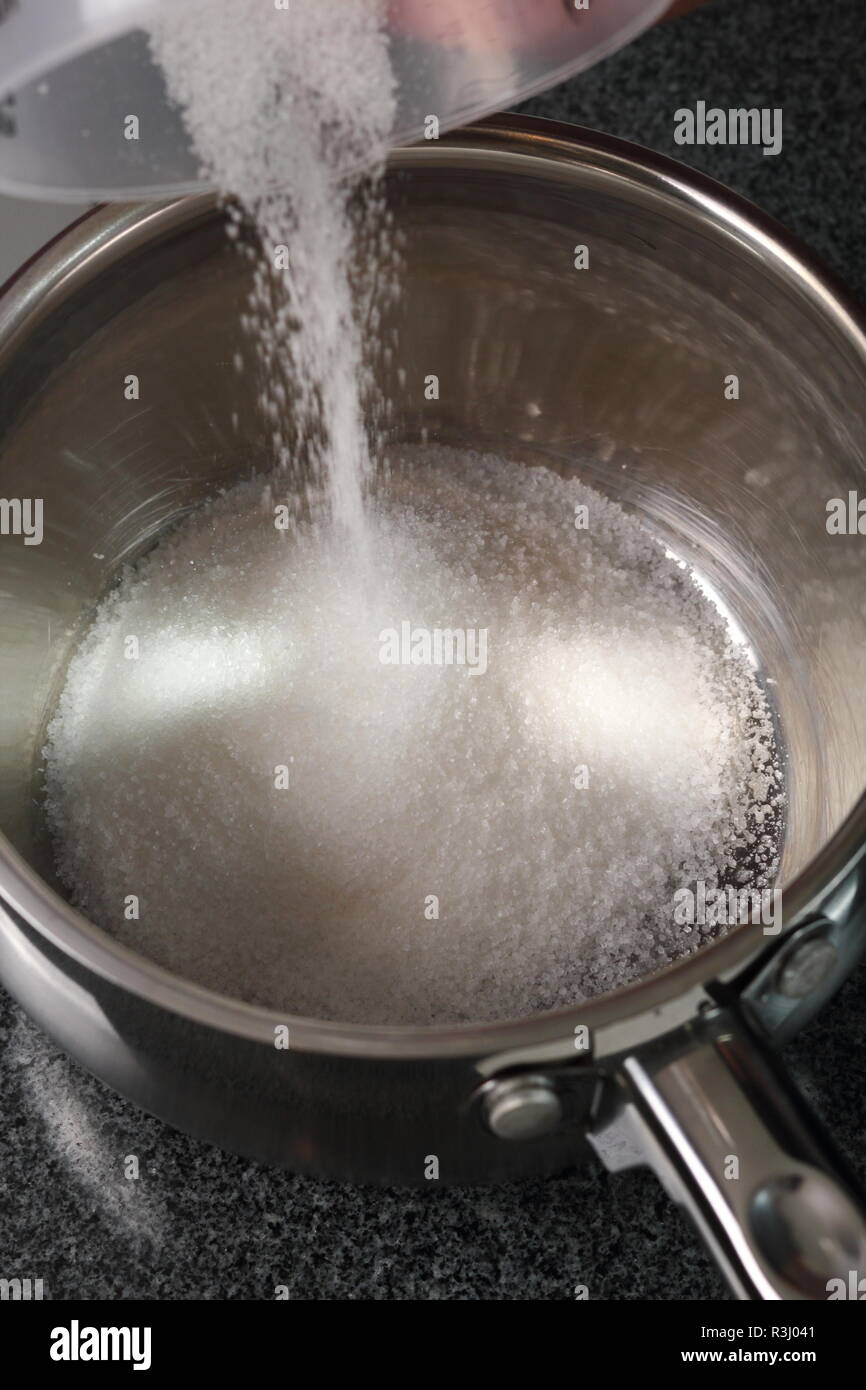 Pouring Sugar into Water Dipper Stock Photo - Alamy