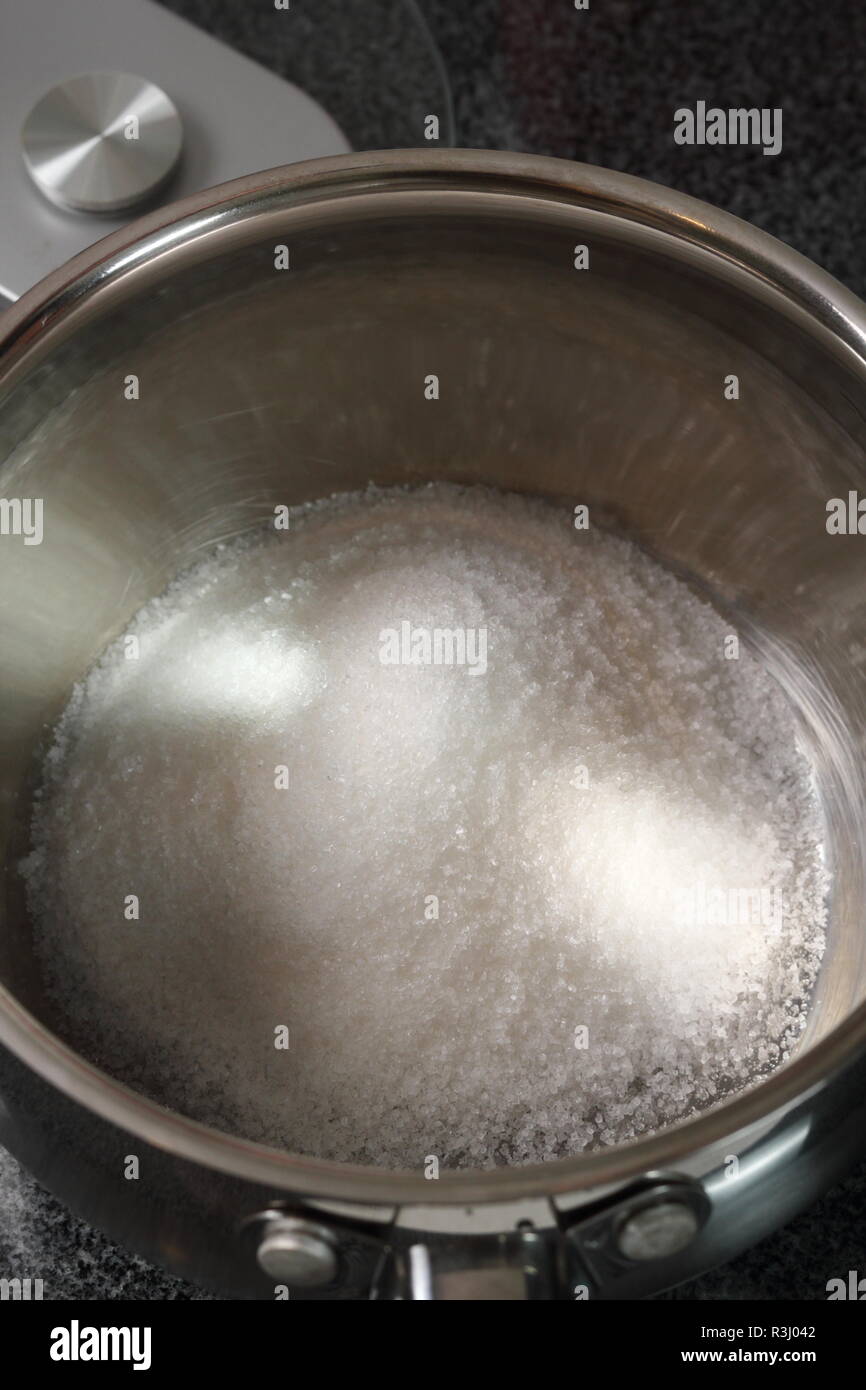 Add sugar into pan. Making Golden Syrup Series Stock Photo - Alamy