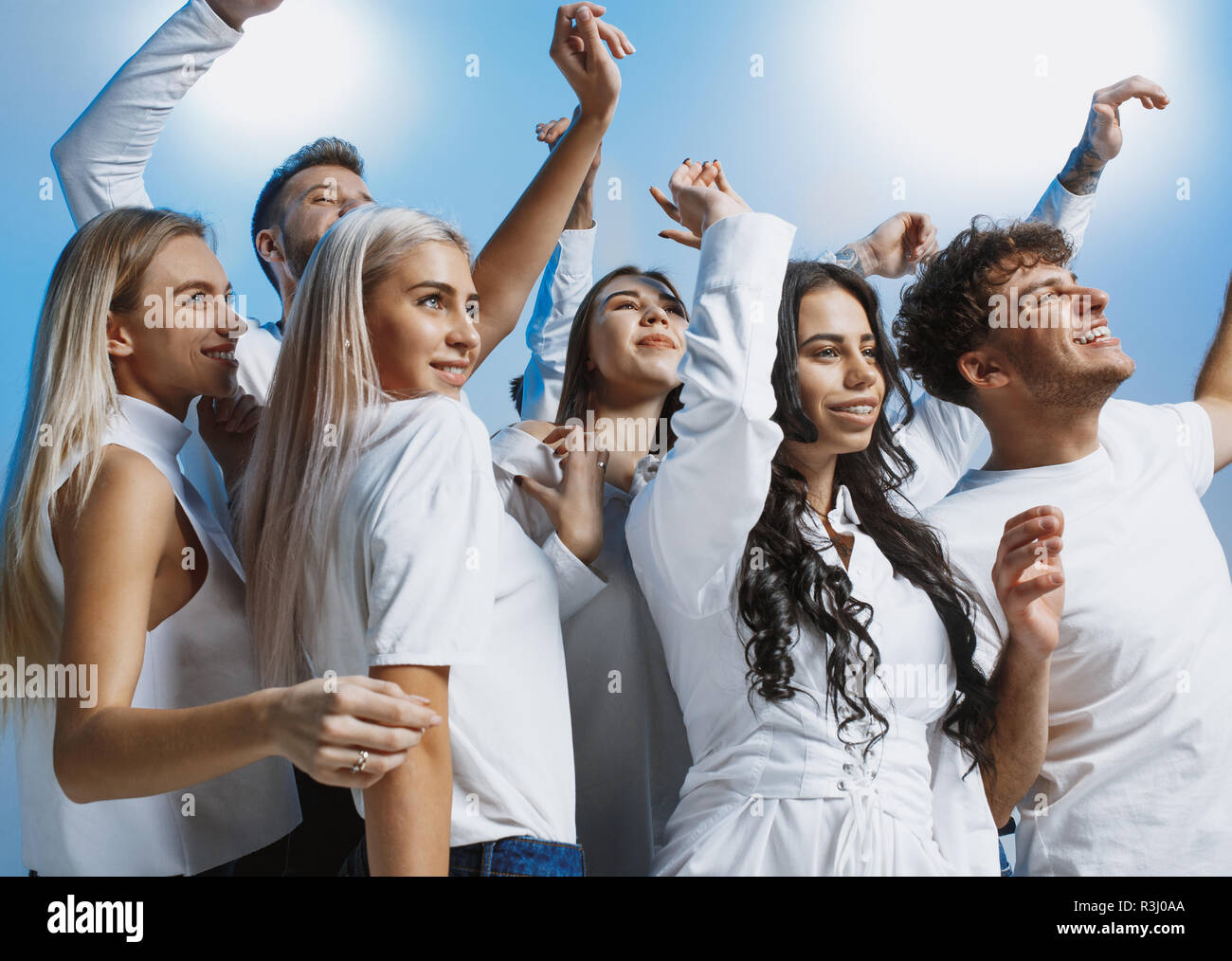 Group of cheerful joyful young people standing and celebrating together ...