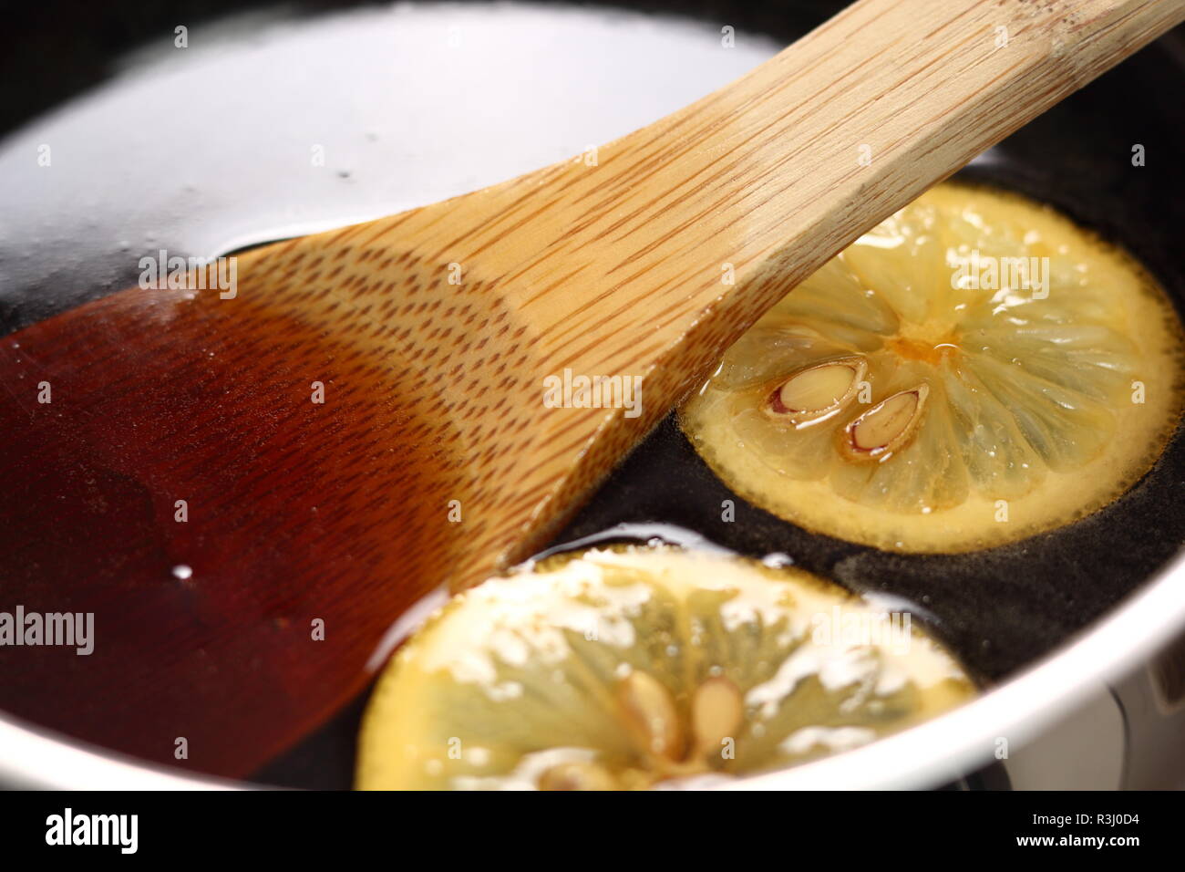 Wooden spoon and lemon slices in treacle syrup Stock Photo - Alamy