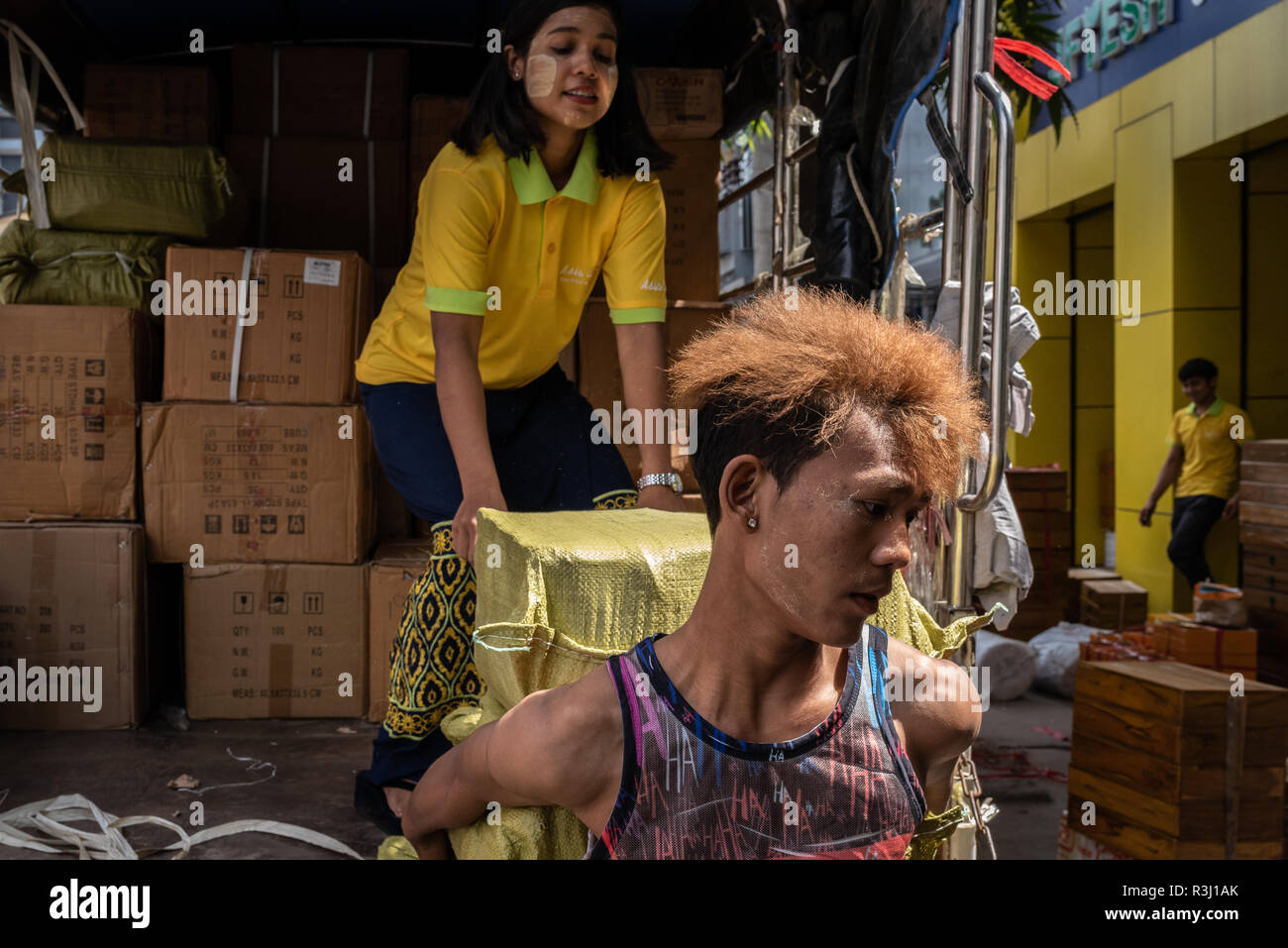 A young man and woman unloading a delivery truck, Mandalay, Myanmar ...