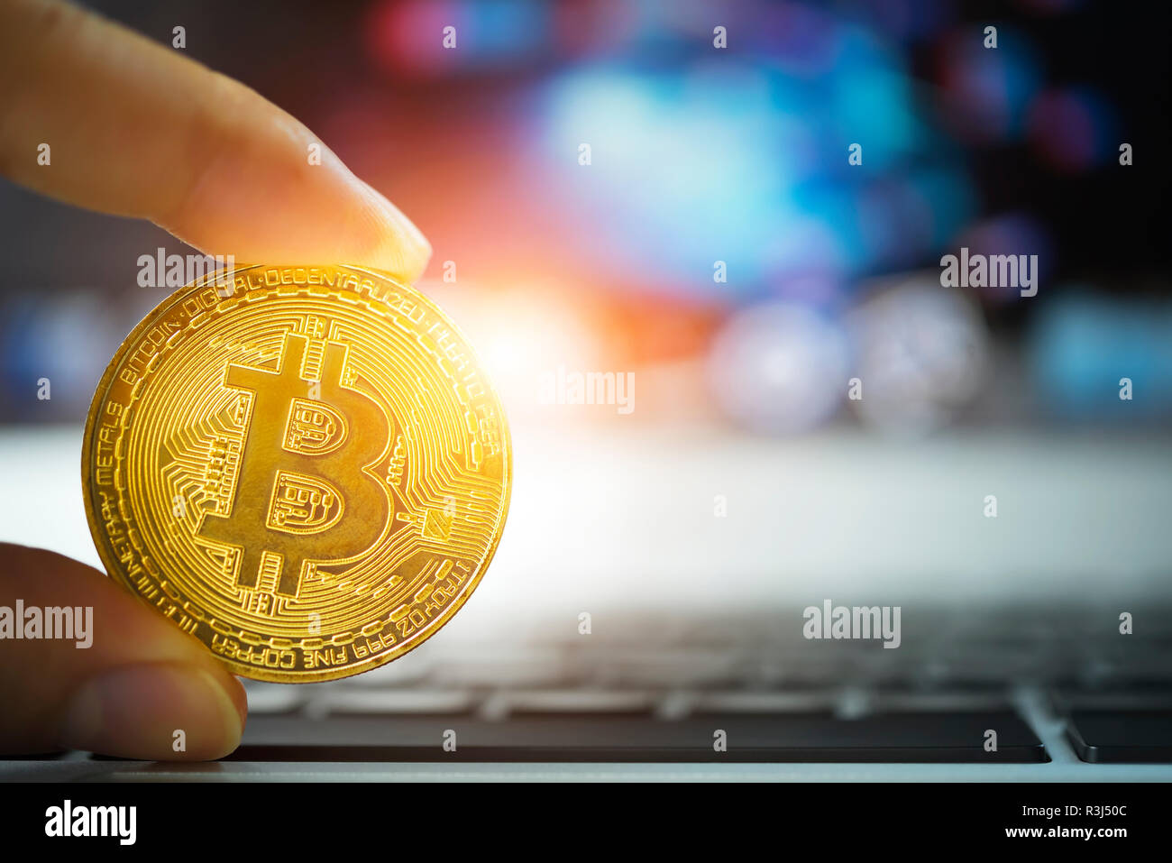 Bitcoin concept. Hand holding golden bitcoin in front of blurred ...