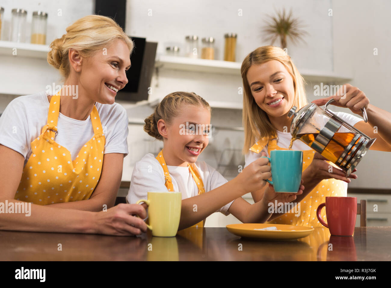 adorable happy child with mother and grandmother drinking tea together ...
