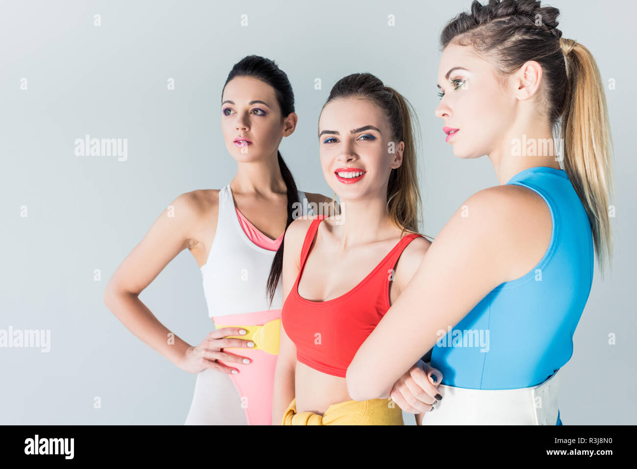 beautiful young sportswomen in sportswear standing together isolated on ...