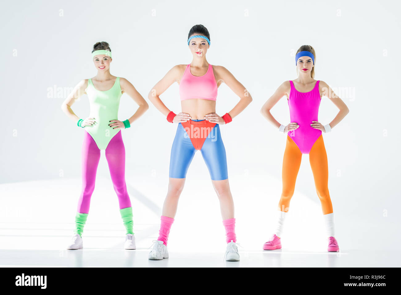 full length view of beautiful sporty girls standing with hands on waist ...