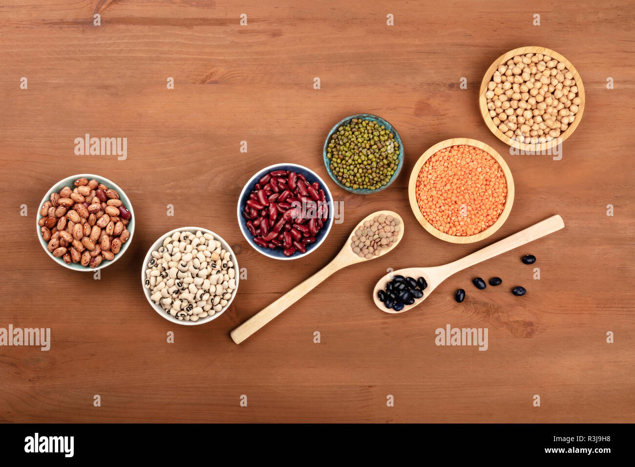 Various types of legumes, shot from above on a dark rustic wooden ...