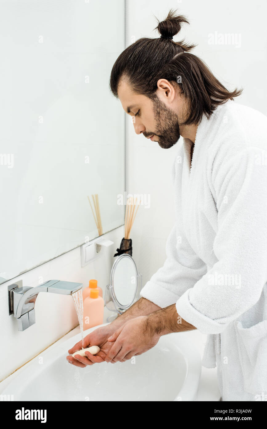adult handsome man in bathrobe washing hands in bathroom Stock Photo ...