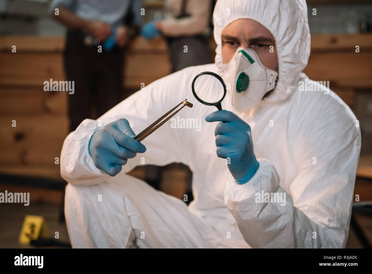 close up of forensic investigator examining evidence with magnifying ...