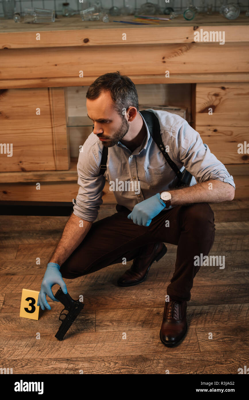 focused male detective collecting evidence gun at crime scene Stock ...
