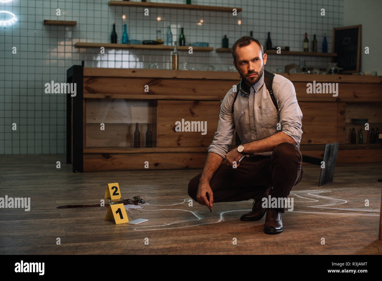 pensive male detective sitting at crime scene Stock Photo - Alamy
