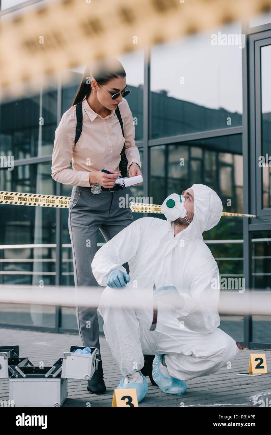 female detective writing explanation to the criminologist at crime ...