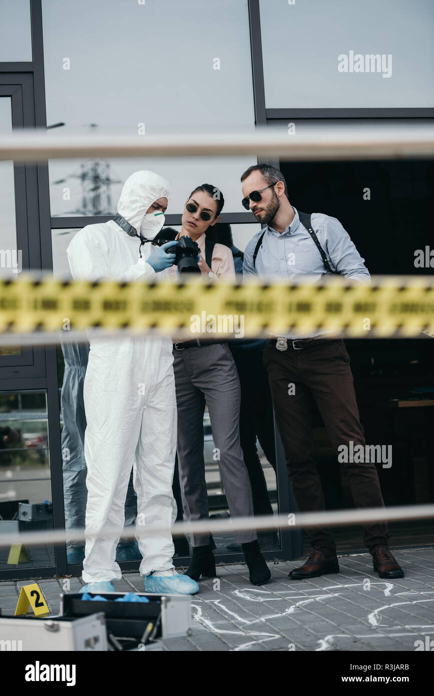 Criminologist Showing Photo From Crime Scene To Two Detectives Stock