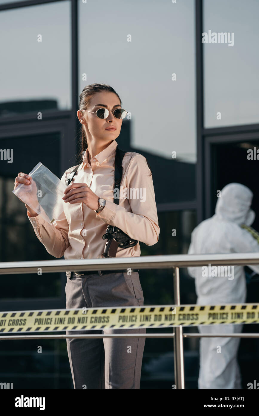 female detective with evidence package in hands Stock Photo - Alamy