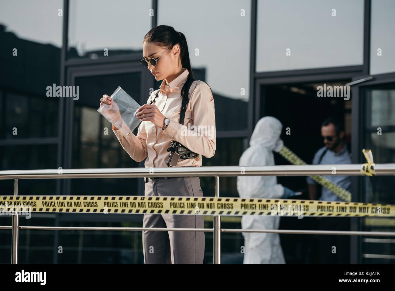 female detective standing and looking at evidence in package Stock ...