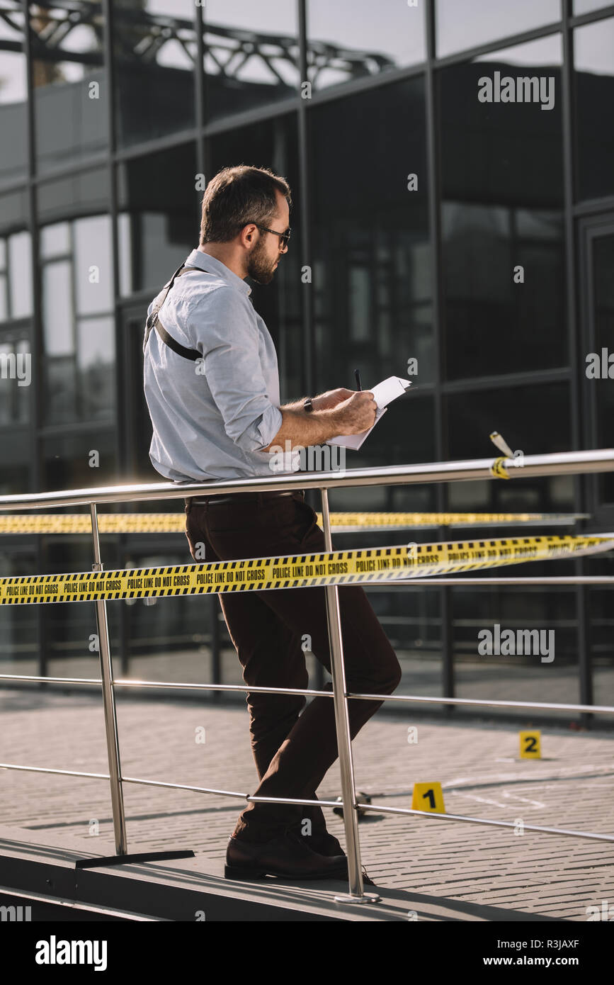 back view of male detective in sunglasses making notes Stock Photo - Alamy
