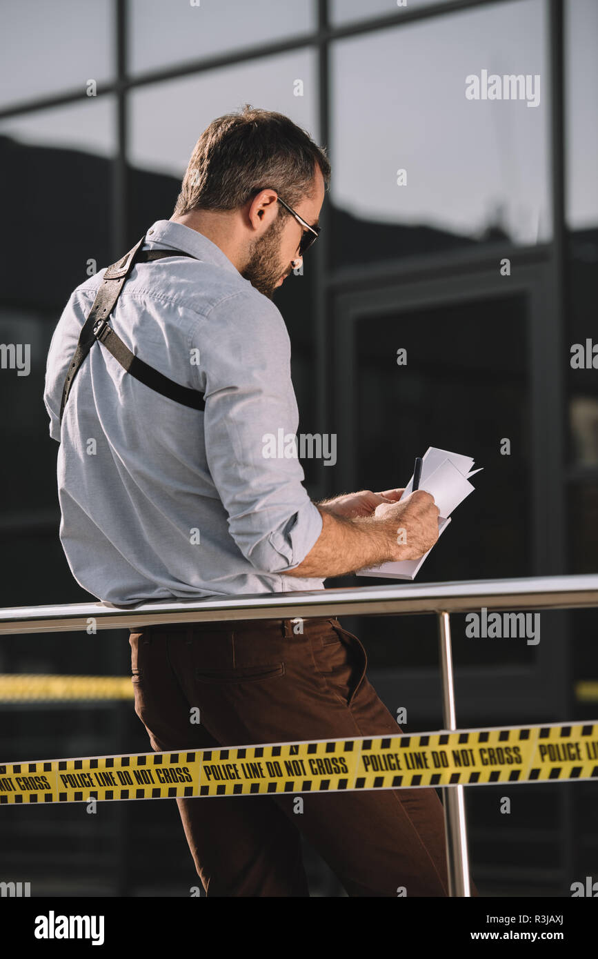 back view of male detective in sunglasses making notes Stock Photo - Alamy