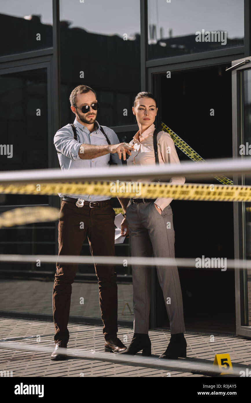 male detective showing something to partner Stock Photo - Alamy