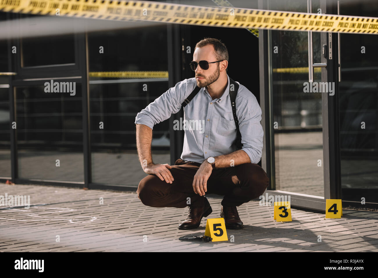 thoughtful male detective sitting at crime scene Stock Photo - Alamy