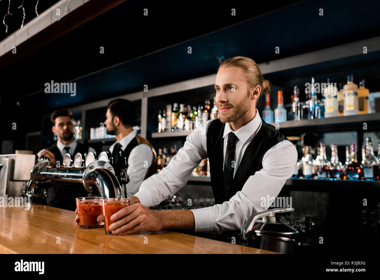 Handsome bartender serving drinks in glasses Stock Photo - Alamy
