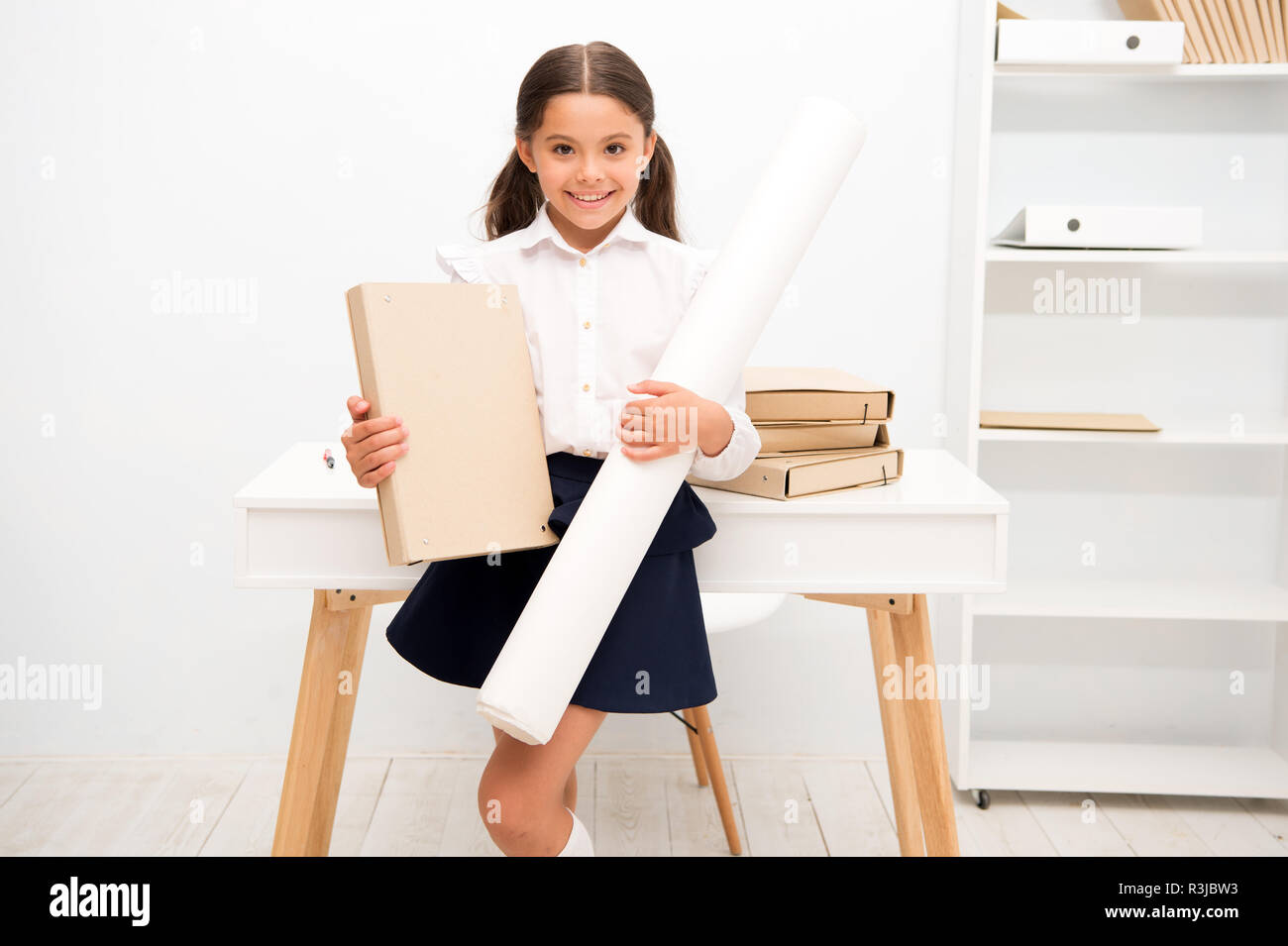 She likes creative tasks. Girl child hold folder and whatman paper ...