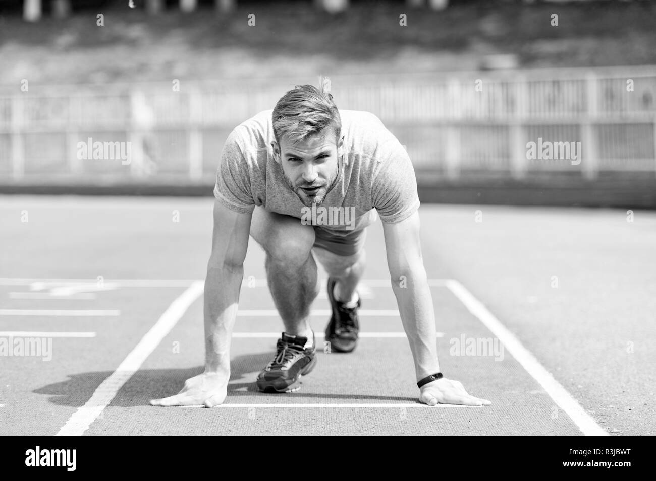Man runner on start position at stadium. Runner in start pose on ...