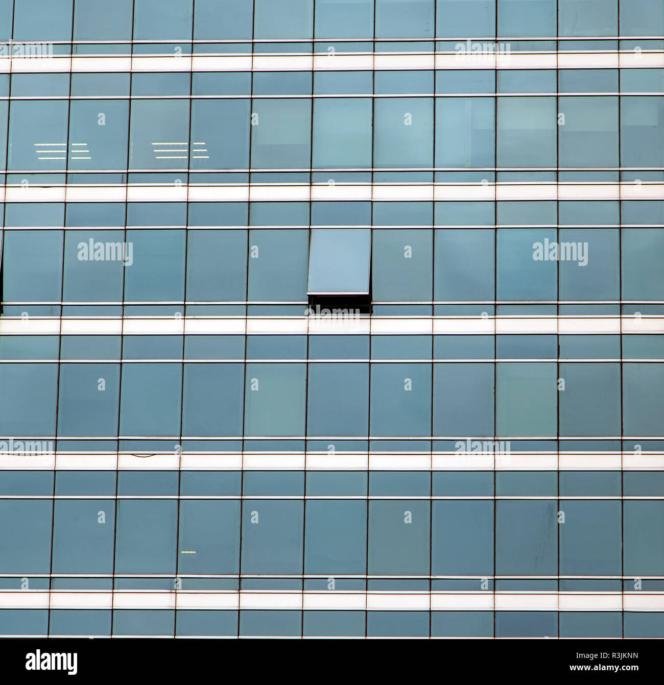 The glass facade of skyscraper with many identical windows and only one ...