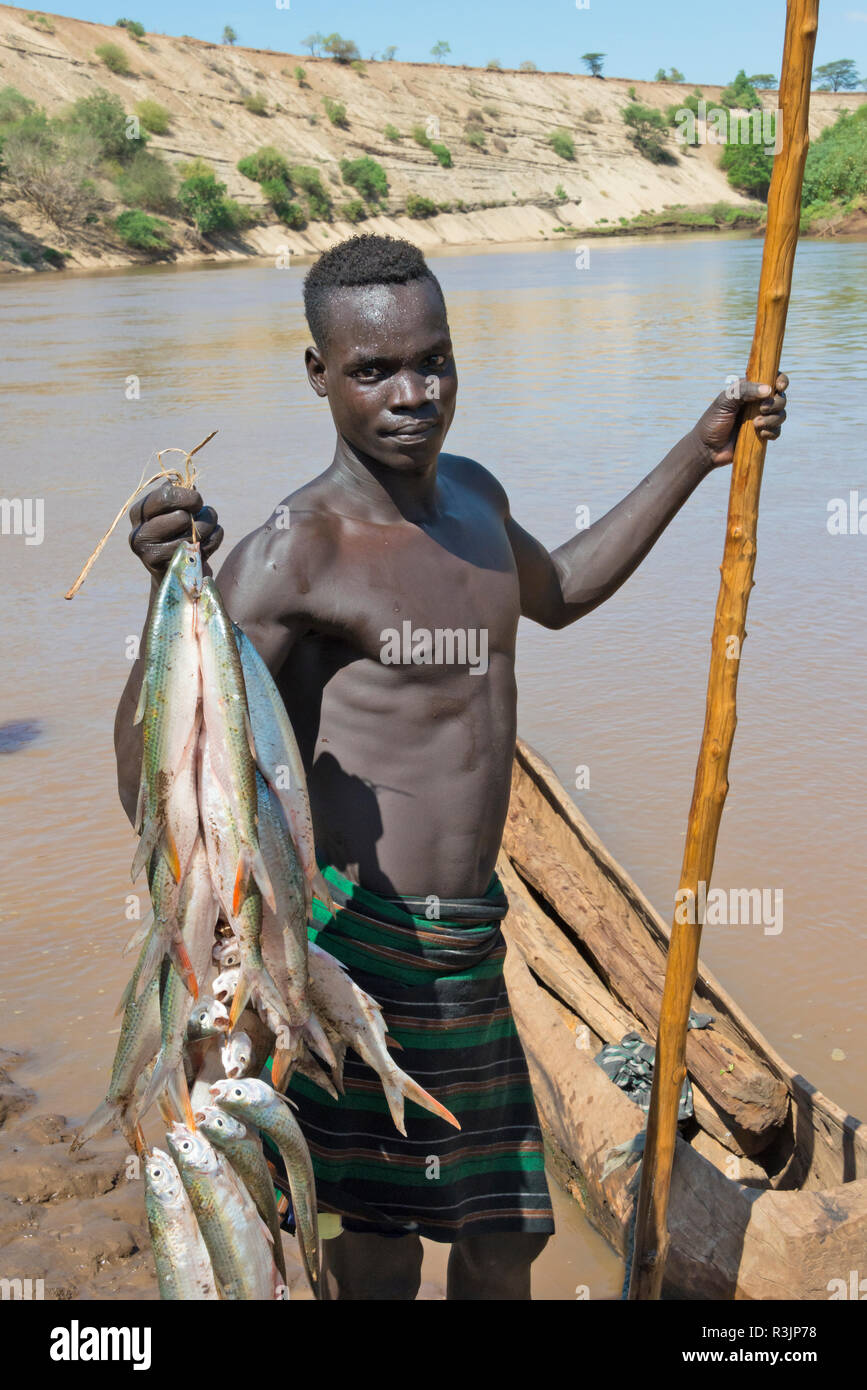 Kara tribe, man with a caught fish on dugout canoe, Lower Omo River ...