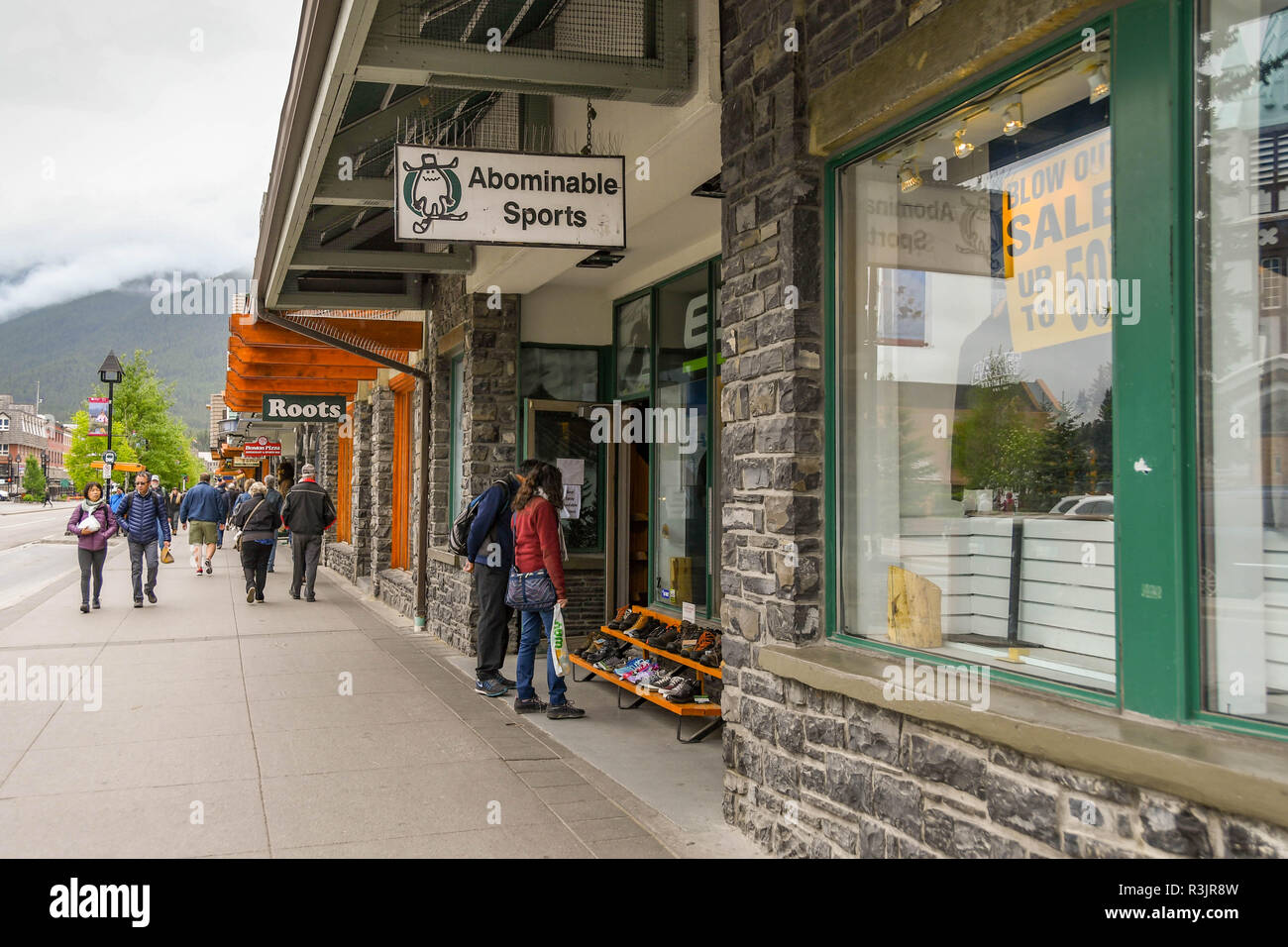 BANFF, AB, CANADA - JUNE 2018: People walking along a row of shops in ...