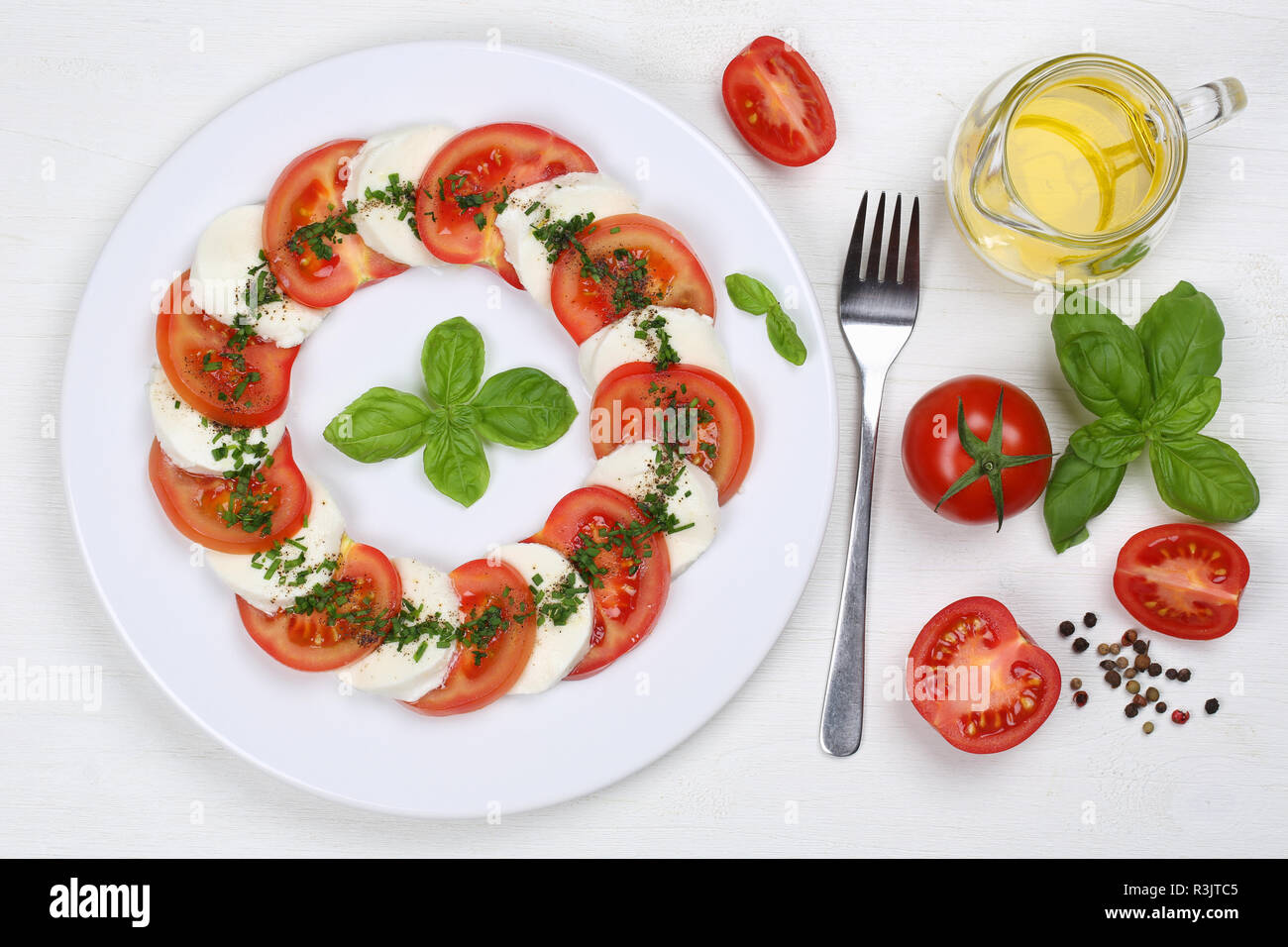 caprese salad with tomatoes and mozzarella on top of wooden board Stock ...