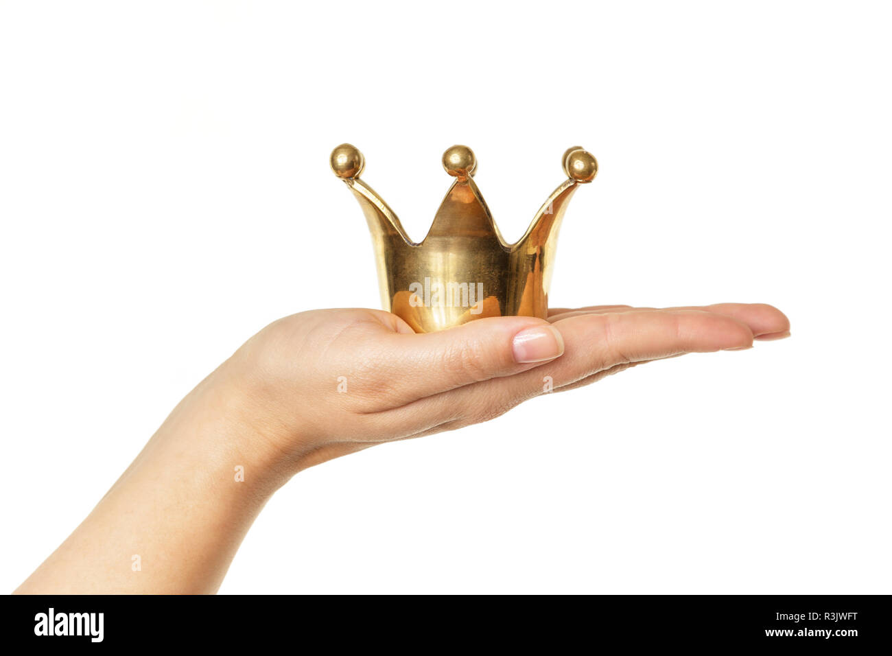 Female hand holding golden crown isolated on white background. Concept ...