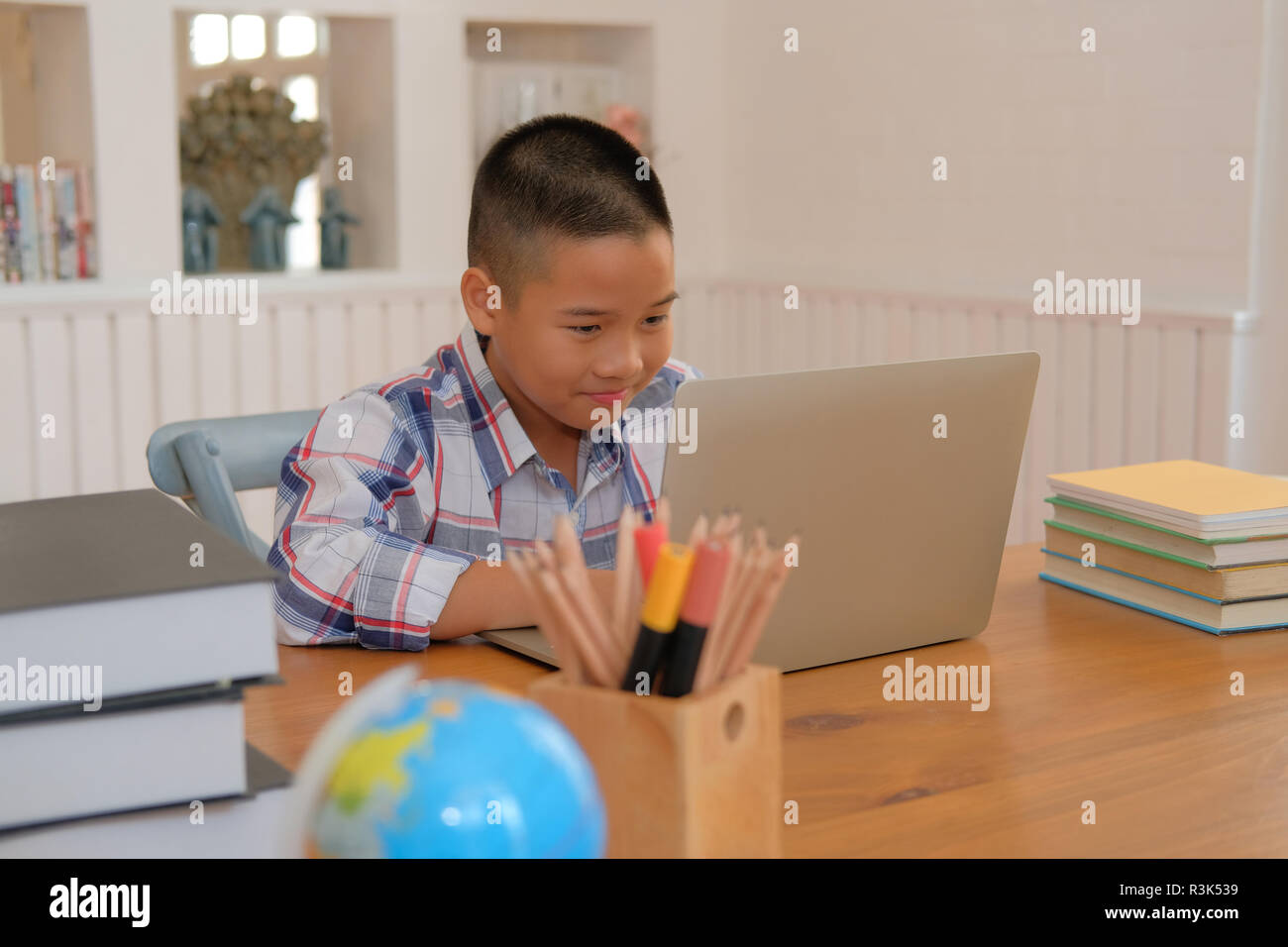 young little asian kid boy studying doing homework. child learning ...