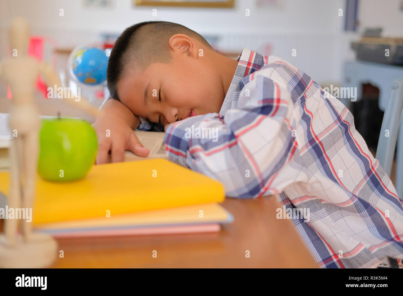 lazy stressed young little asian kid boy resting sleeping on desk ...