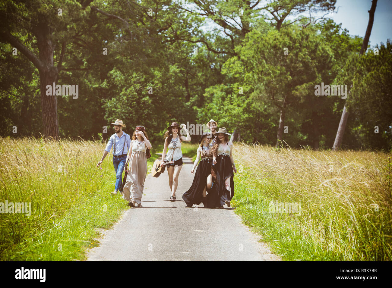 Group of young hipster front view, walking on country road Stock Photo ...