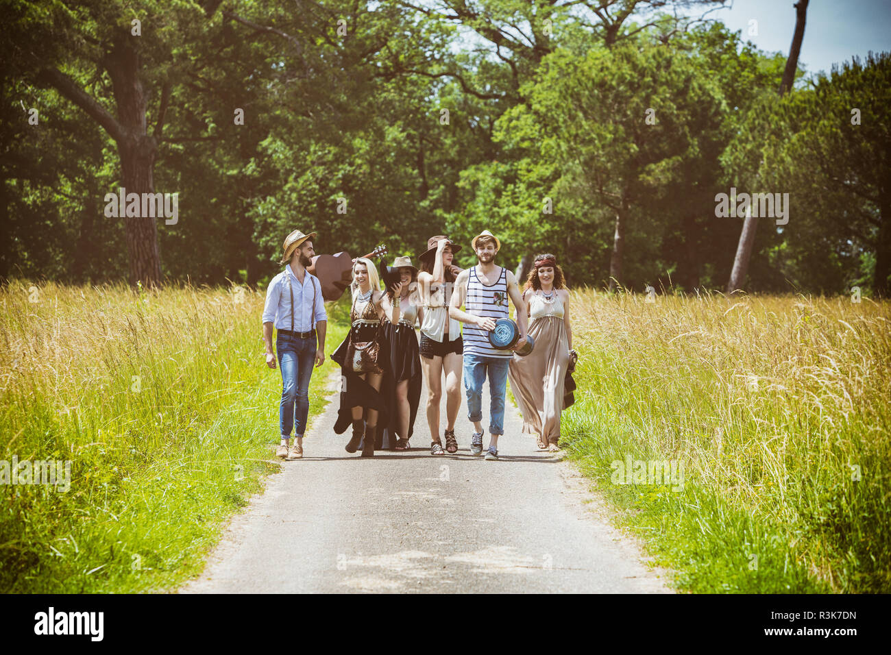 Group of young hipster front view, walking on country road Stock Photo ...