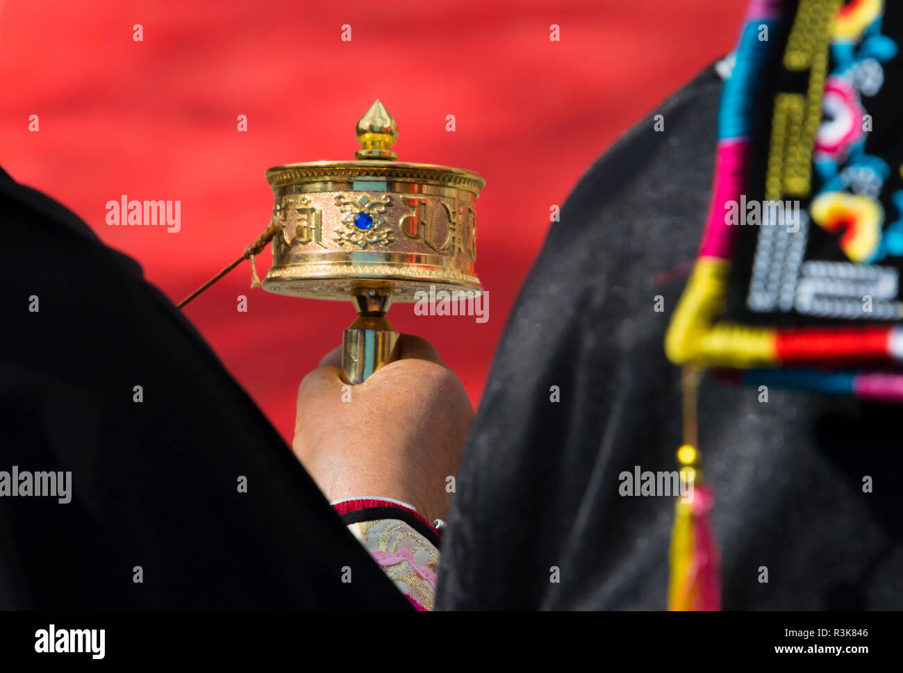 Jiarong Tibetan woman in traditional clothing holding praying wheel ...