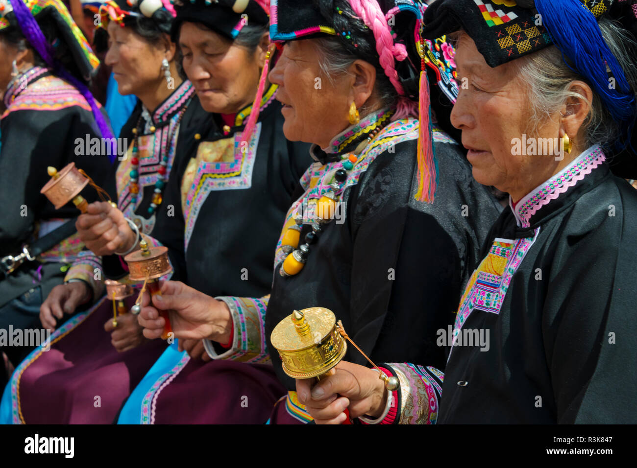 Jiarong Tibetan woman in traditional clothing holding praying wheel ...