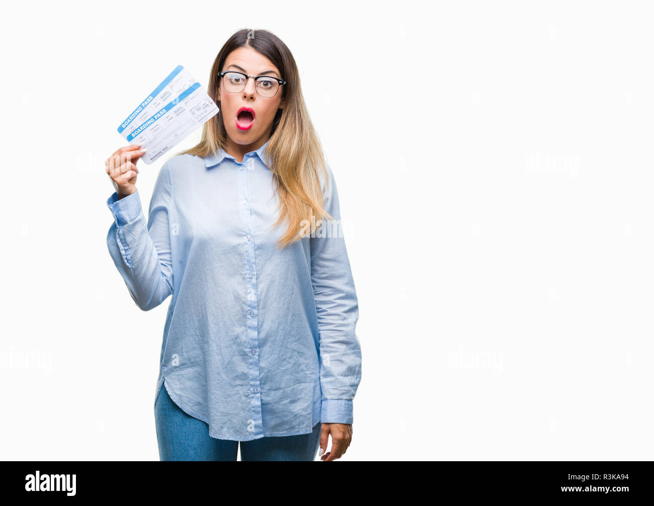 Young beautiful woman holding boarding pass over isolated background ...