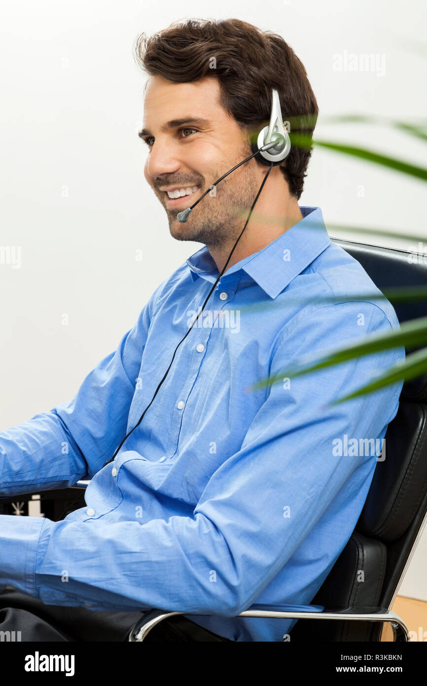 attractive young man with headset in the office customer service ...