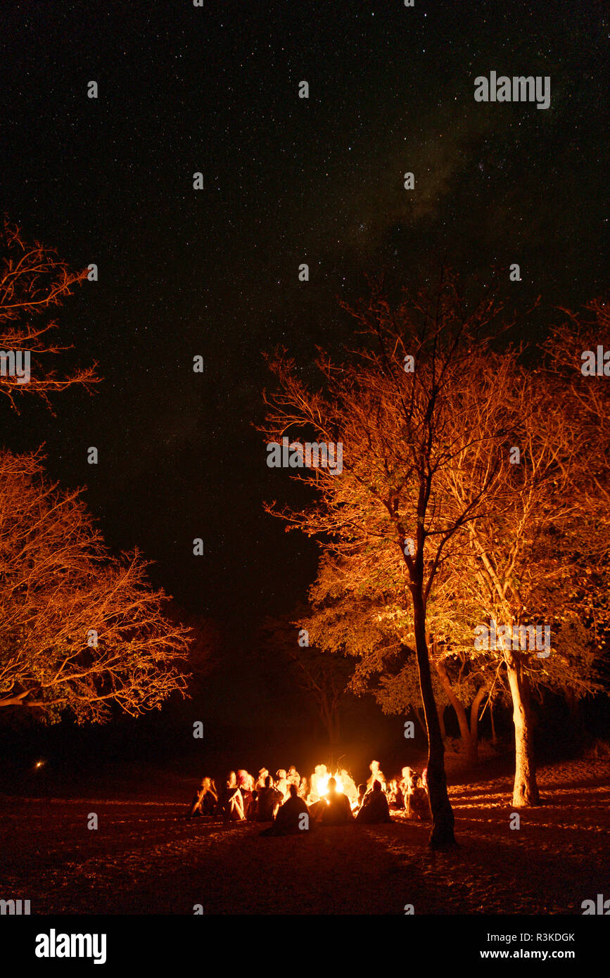 San Bushmen villager sitting at campfire beneath a starry sky, eastern ...