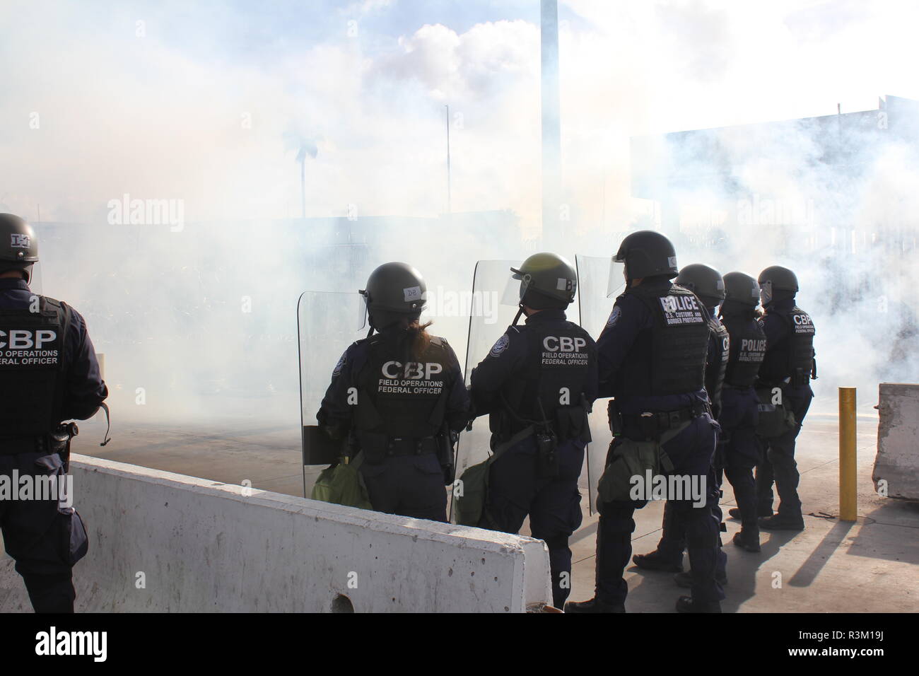 U.S. Customs and Border Patrol agents with riot shields and tear gas ...