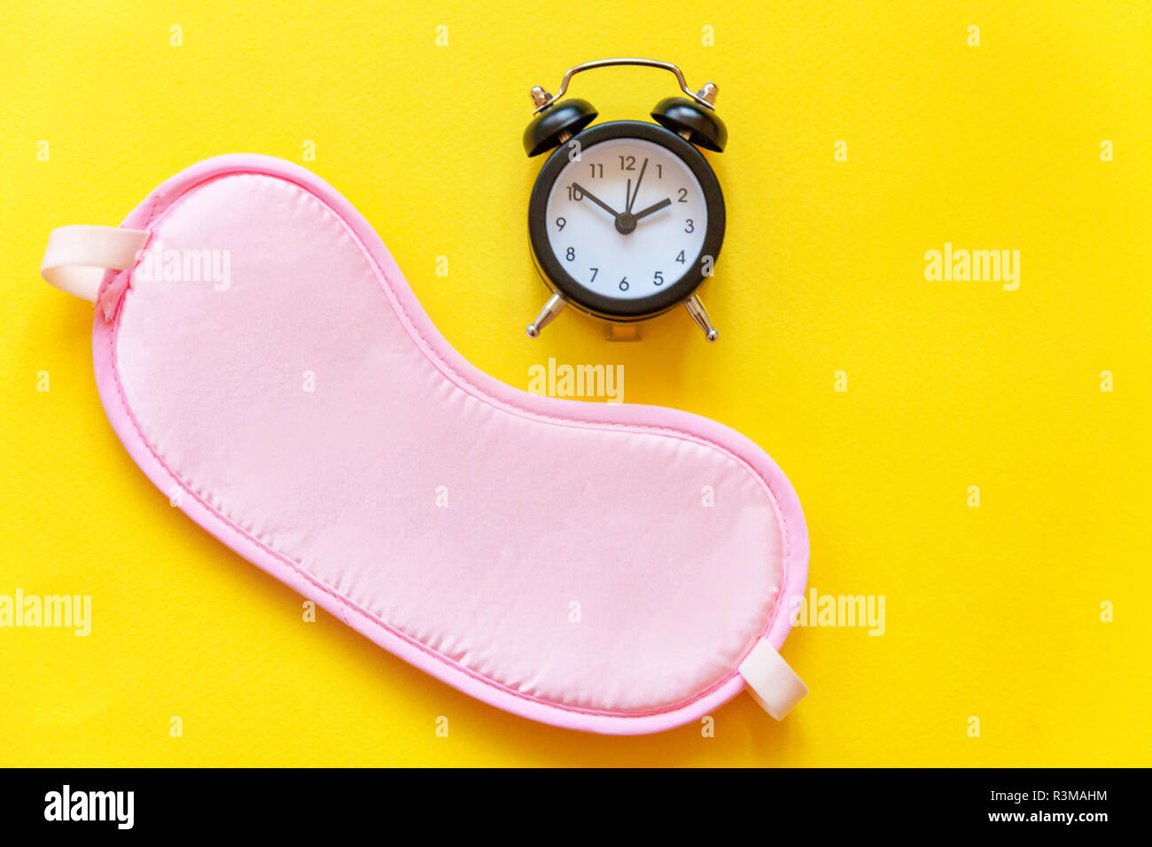 Sleeping eye mask, alarm clock isolated on yellow colourful trendy ...