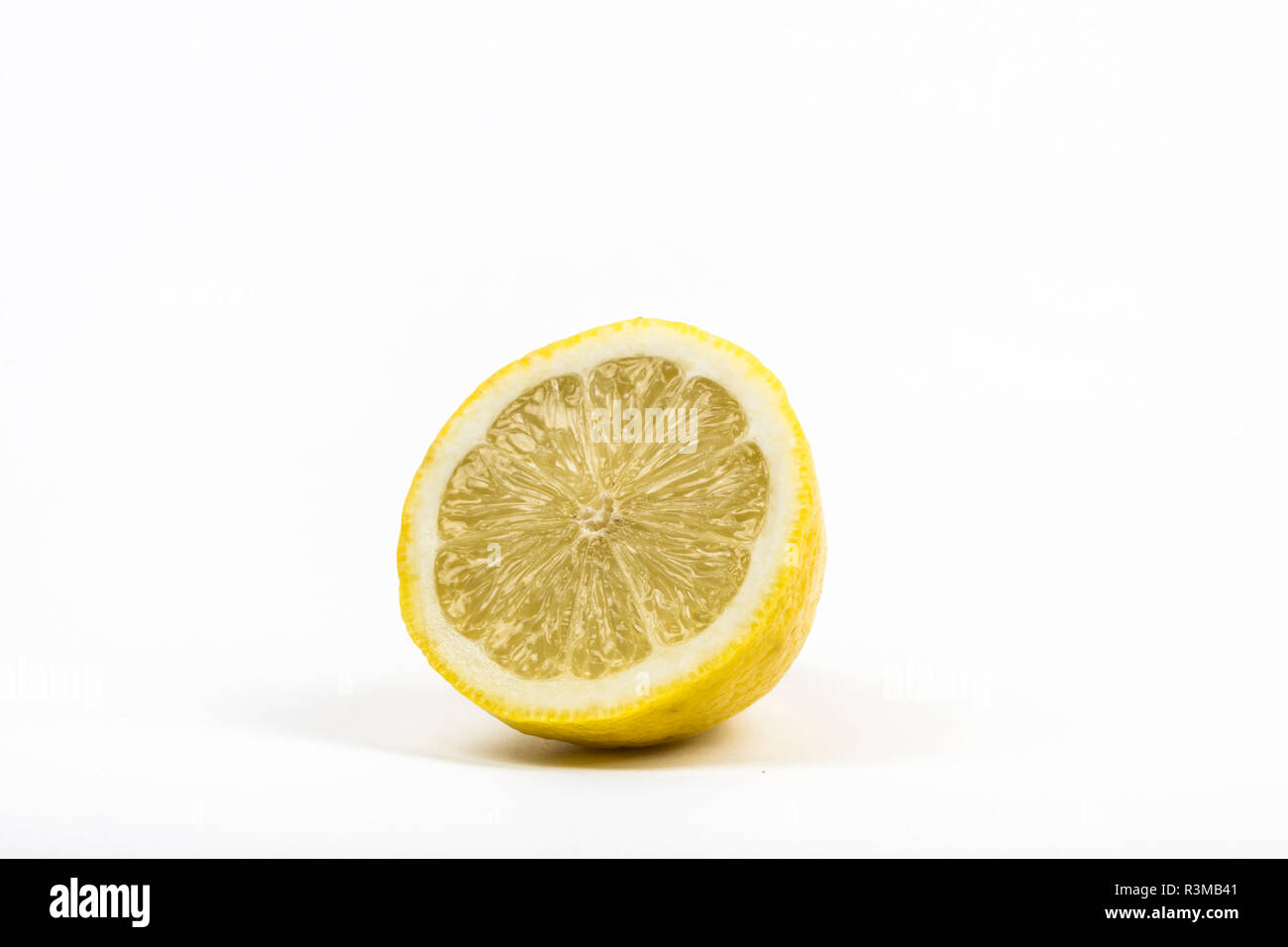 A half cut lemon isolated in white with copy space Stock Photo - Alamy