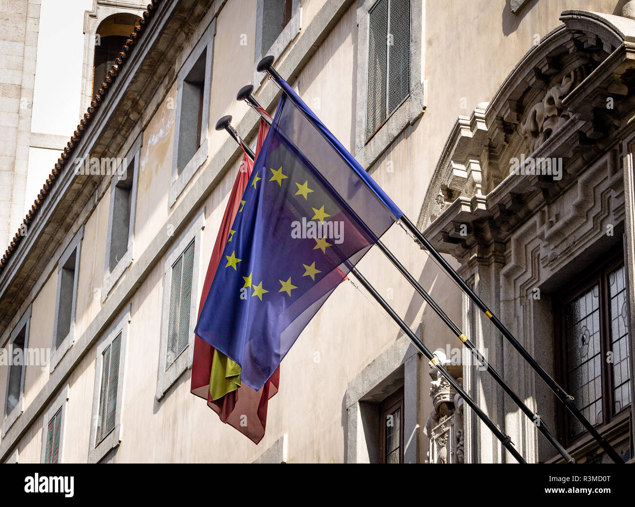 The flags of the European Union and Spain are raised on a balcony from ...